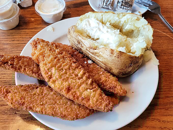 Golden-crusted walleye fillets beside a loaded baked potato&mdash;proof that sometimes the simplest pleasures are the most satisfying.