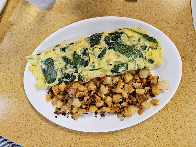 This spinach omelet doesn't need a passport to transport you somewhere wonderful, though the home fries might require their own zip code.