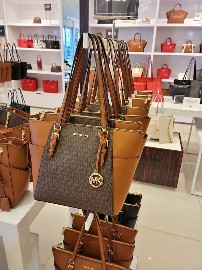 The handbag display at Michael Kors &ndash; where leather dreams come with gold hardware and the promise of organized chaos inside.
