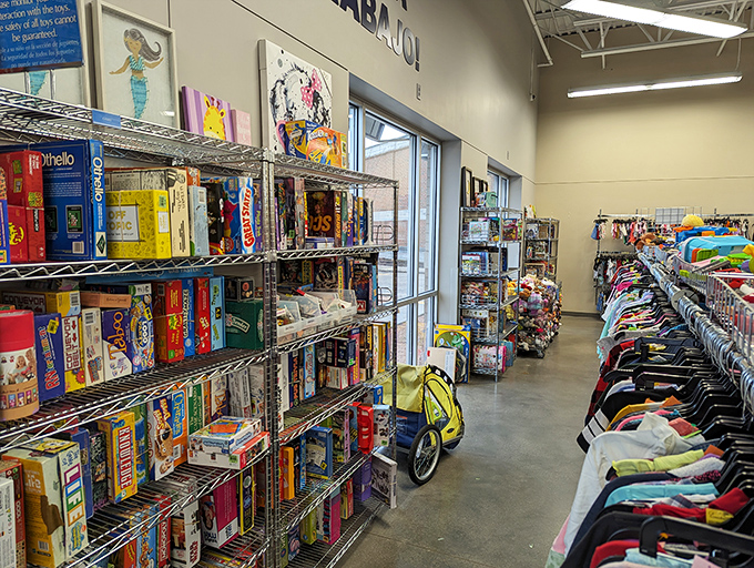 Board games and toys share space with clothing, creating that delightful thrift store juxtaposition where childhood nostalgia meets practical needs.