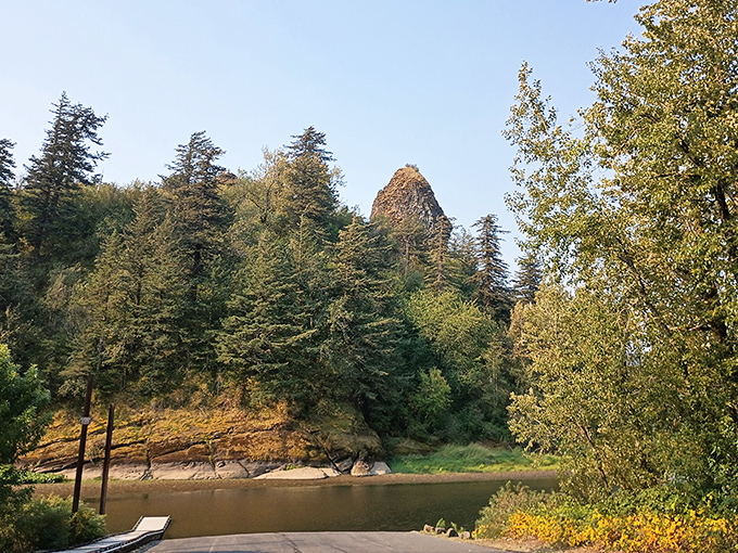 The rock formation peeks through the trees like a shy celebrity, reminding visitors that the best views often require a bit of patience.