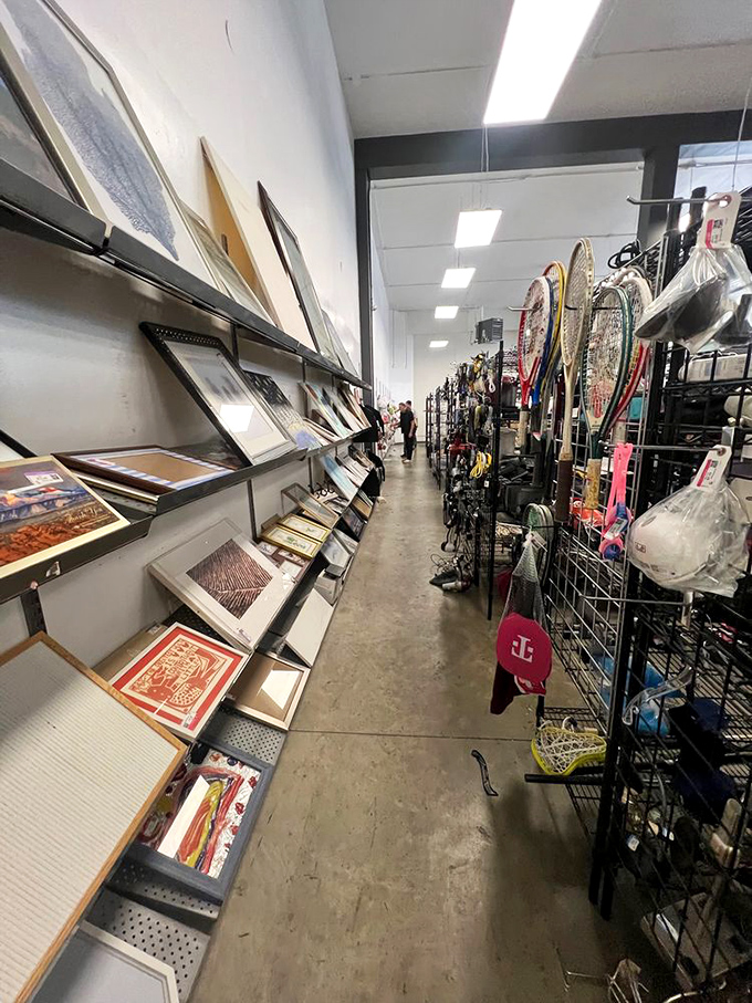 Art and sporting goods coexist in beautiful thrift harmony. Where else can you find a lighthouse painting next to tennis rackets?