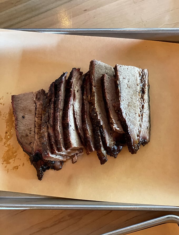 Brisket sliced with the precision of a surgeon's hand. That pink smoke ring isn't just pretty &ndash; it's the barbecue equivalent of a Michelin star.