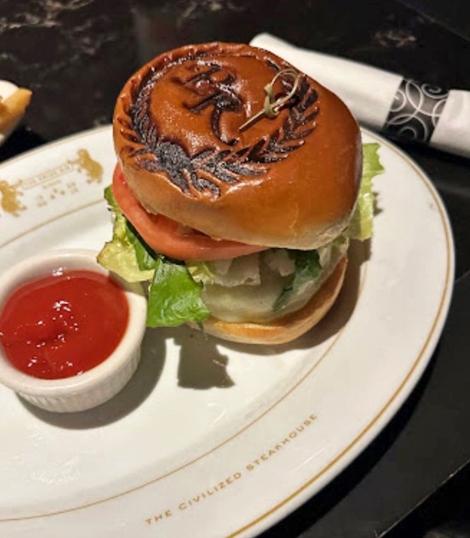 Even the burger gets the royal treatment, branded with the restaurant's logo like a delicious status symbol on a perfect bun.