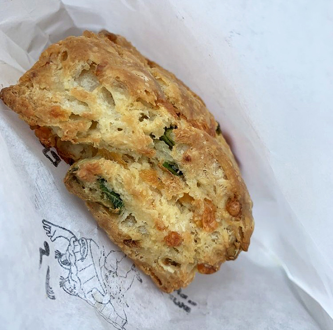 Behold the legendary scallion biscuit in its natural habitat &ndash; layers upon buttery layers with green flecks promising flavor that'll haunt your dreams for weeks.