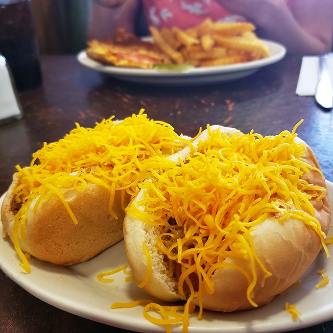 Behold the cheese coney in its natural habitat&mdash;a mountain of finely shredded cheddar creating a protective orange blanket over Cincinnati's signature contribution to hot dog artistry.