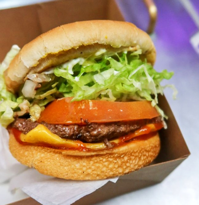 Burger architecture at its finest. The structural integrity of that perfectly toasted bun supporting fresh veggies and a juicy patty deserves an engineering award.