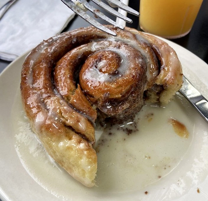 The cinnamon roll doesn't merely sit on the plate&mdash;it lounges, confident in its gooey, spiraled perfection, daring you to resist its siren call. 