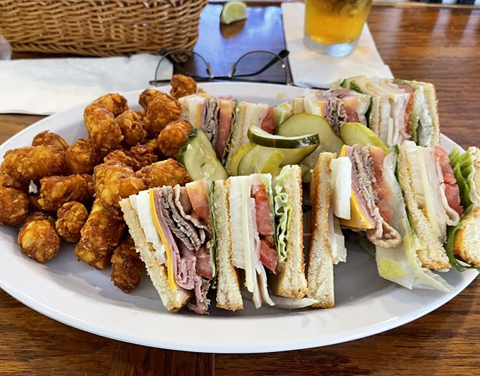 The club sandwich: architectural marvel, hunger vanquisher. Paired with golden tater tots, it's the lunch equivalent of a warm hug from an old friend.