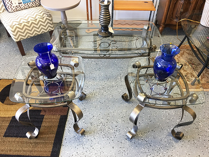 Sleek glass tables flanked by cobalt blue vases create an unexpected moment of zen amid the treasure-hunting chaos.