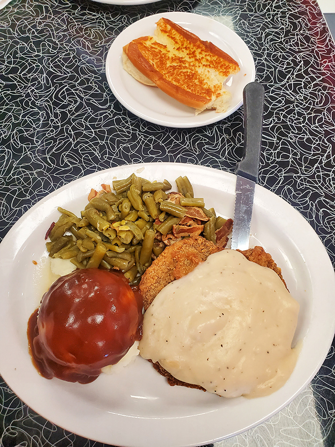 Southern diplomacy on a plate: country fried steak with white gravy and green beans negotiating peaceful coexistence.