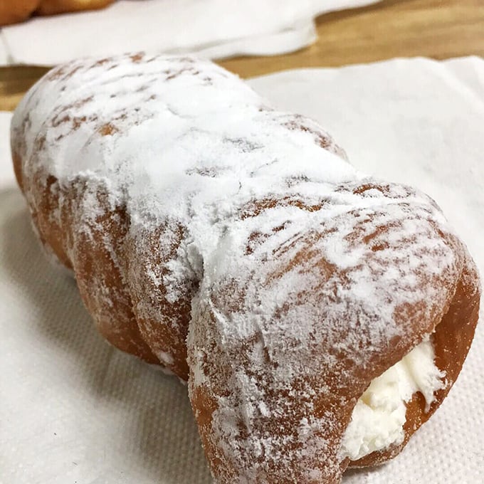 The cream horn &ndash; where powdered sugar meets cloud-like filling in a delicate pastry embrace. Worth every napkin you'll need afterward.