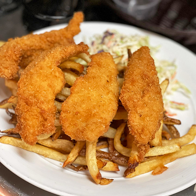 Golden-battered fish perched atop a mountain of fries. Neptune himself would approve of this crispy treasure from the deep.