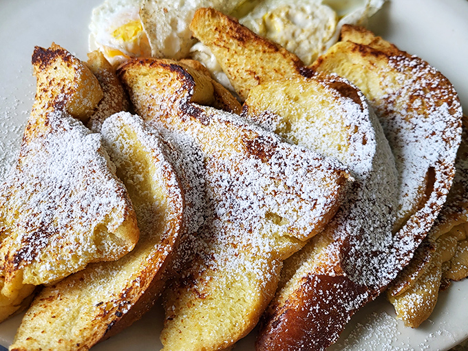 French toast that arrives dressed in powdered sugar like it's ready for a fancy ball.