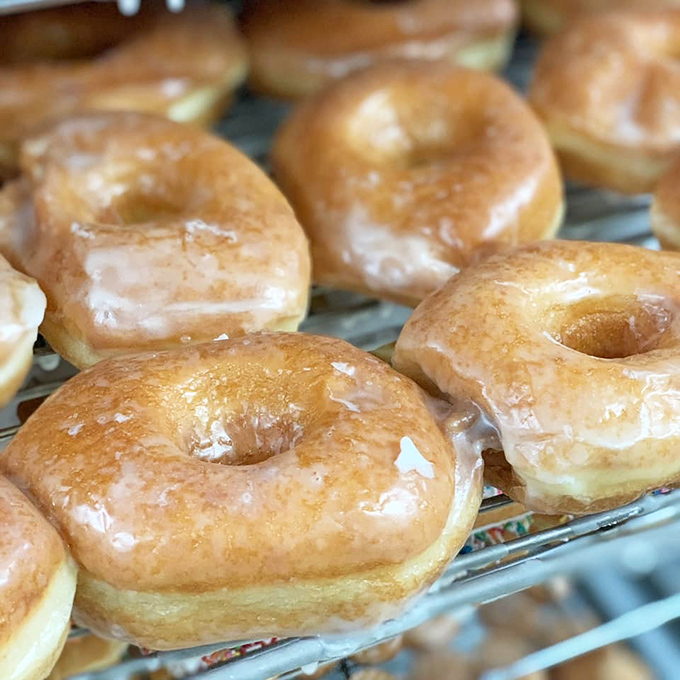 Glazed donuts in their natural habitat &ndash; glistening under bakery lights. These aren't just donuts; they're edible sunshine with a side of nostalgia.
