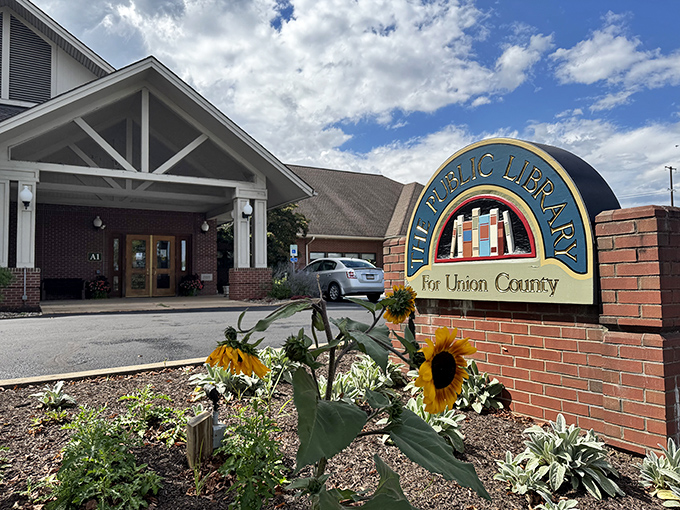 The Public Library's welcoming entrance, flanked by cheerful sunflowers, stands as a reminder that the best adventures still begin between pages.