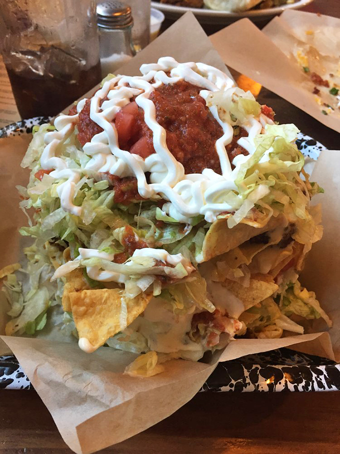 The Slop Bucket Nachos defy their humble name, rising like a mountain of Tex-Mex perfection that requires both strategy and stamina.
