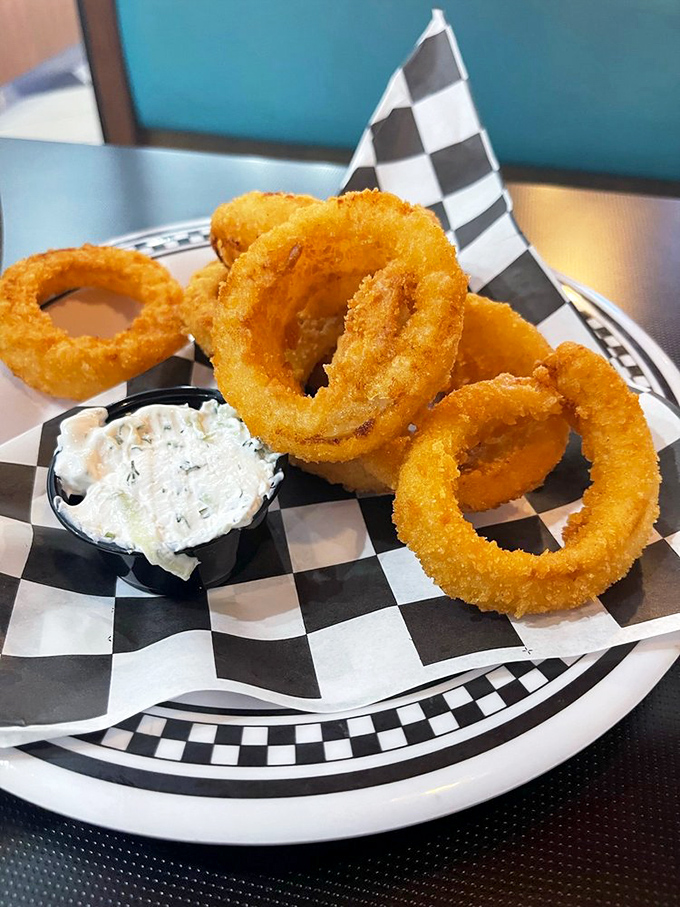 Onion rings that shatter with each bite, paired with a dipping sauce that makes you question why you'd ever eat vegetables any other way.