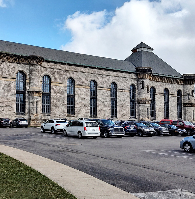 Not your average tourist attraction parking lot. Each car represents someone drawn to explore the thin line between architectural beauty and institutional dread.