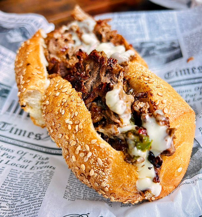Philly's iconic sandwich gets the royal treatment here &ndash; tender meat, caramelized onions, and cheese that stretches like your favorite sweatpants after Thanksgiving dinner.