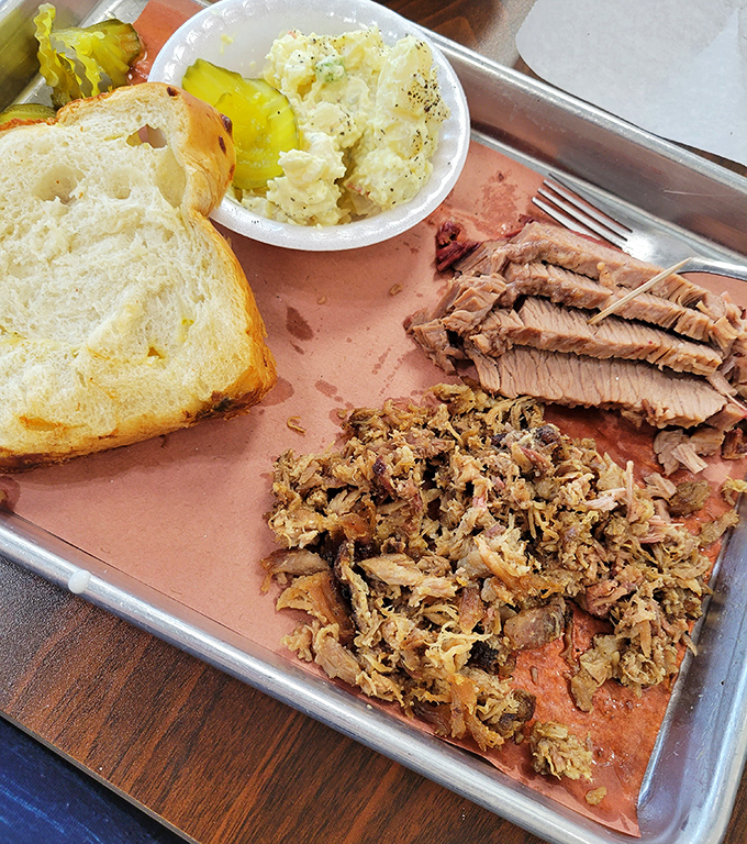 A study in contrasts: tender pulled pork, creamy potato salad, and white bread. Simple perfection doesn't need to show off.