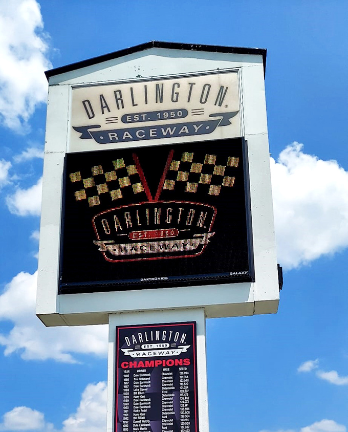 The Lady in Black announces herself. Darlington's iconic signage stands tall against Carolina blue skies, a beacon for speed enthusiasts since 1950.