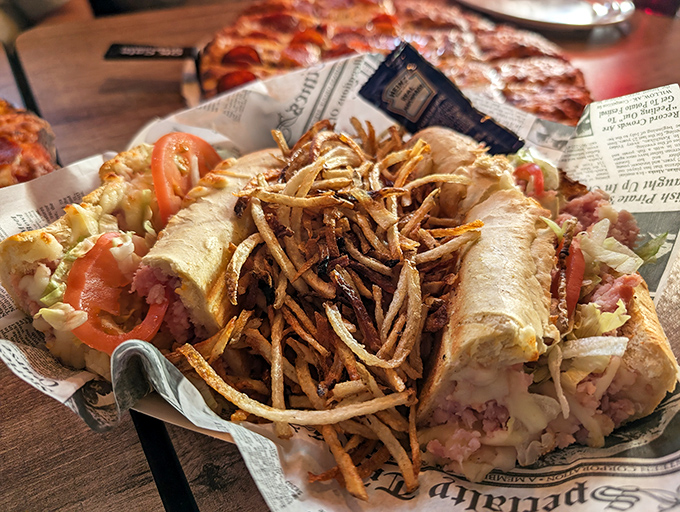 A sandwich that requires both hands and a strategy—layers of goodness topped with those addictive shoestring fries for textural genius.