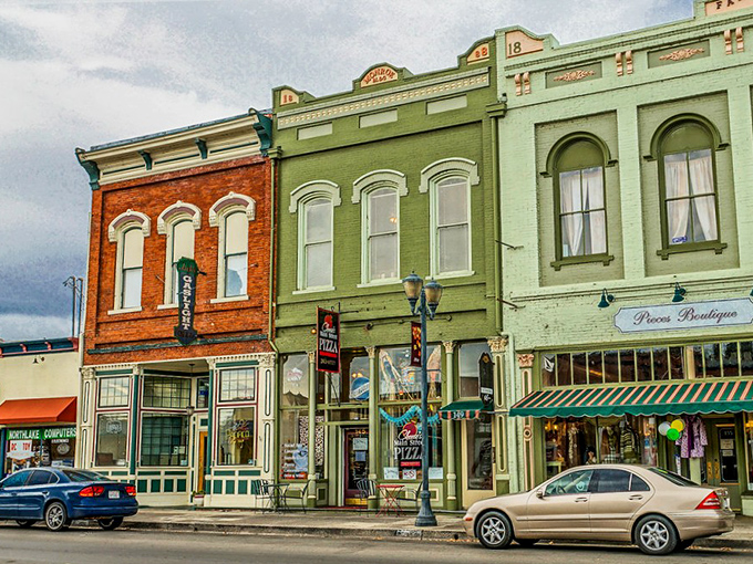 Main Street's pastel-colored storefronts create a real-life watercolor painting, where Juicy's Pizza sign promises comfort in every slice.
