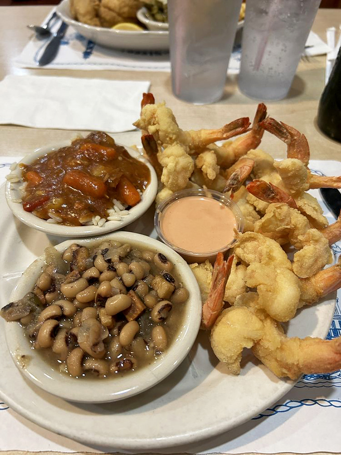 The holy trinity of Southern comfort: perfectly fried shrimp, black-eyed peas, and something saucy on rice. This plate doesn't need a filter&mdash;it needs a trophy.
