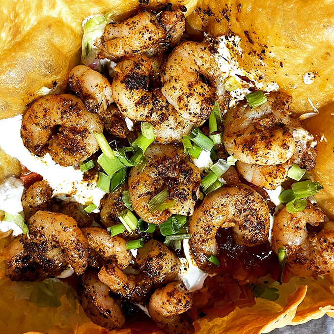 Blackened shrimp nestled on a bed of creamy goodness. If heaven had a taste, it might just be this perfect harmony of spice and seafood.