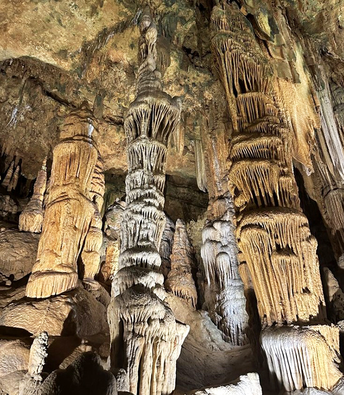 A visitor pauses to appreciate nature's handiwork, standing before stone curtains that took longer to create than human civilization has existed.