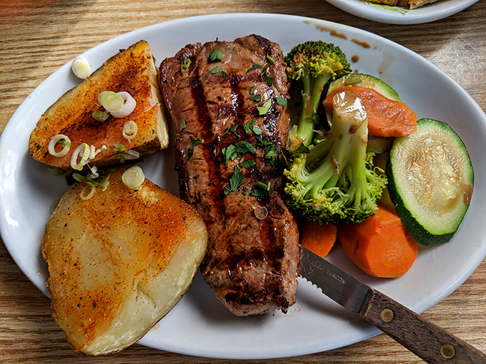 Steak night done right&mdash;perfectly seared, knife standing by, with vegetables pretending they're the reason you ordered this plate.