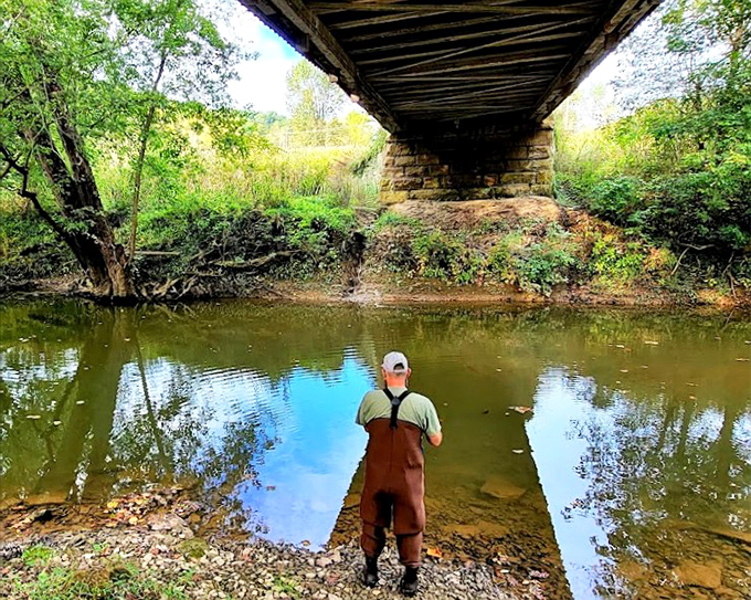 Peaceful fishing moments under the covered bridge bring calm reflections, with nature&rsquo;s beauty surrounding the gentle flow of the stream.