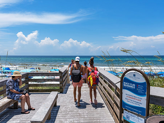 The universal beach pilgrimage: families loaded with gear, making their way to the shoreline like determined explorers discovering paradise.