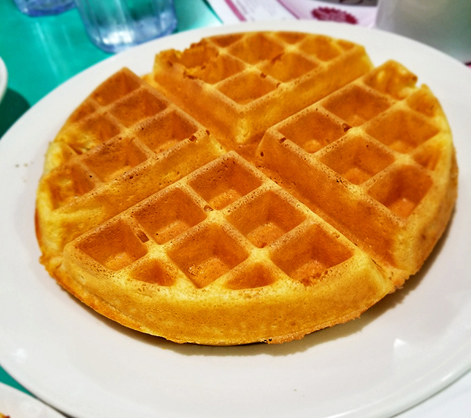 The Belgian waffle stands proud and golden, its perfect grid of squares practically begging for a river of maple syrup to fill every delicious valley.