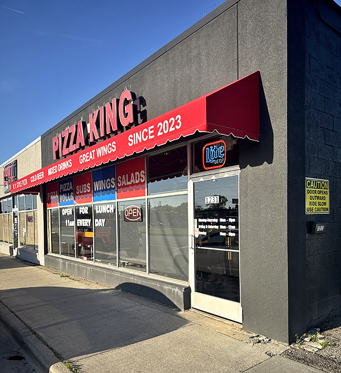 Pizza King's bold red signage announces royal treatment for every customer craving that perfect slice experience.