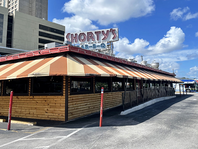 That iconic striped awning has sheltered generations of barbecue lovers from everything except sauce-stained shirts.
