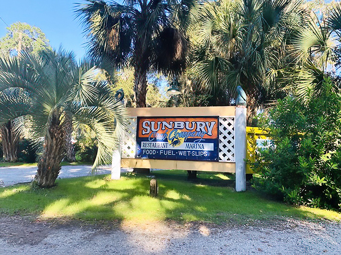 Sunbury Crab Company's sign nestled among palm trees &ndash; nature's way of pointing you toward incredible seafood.