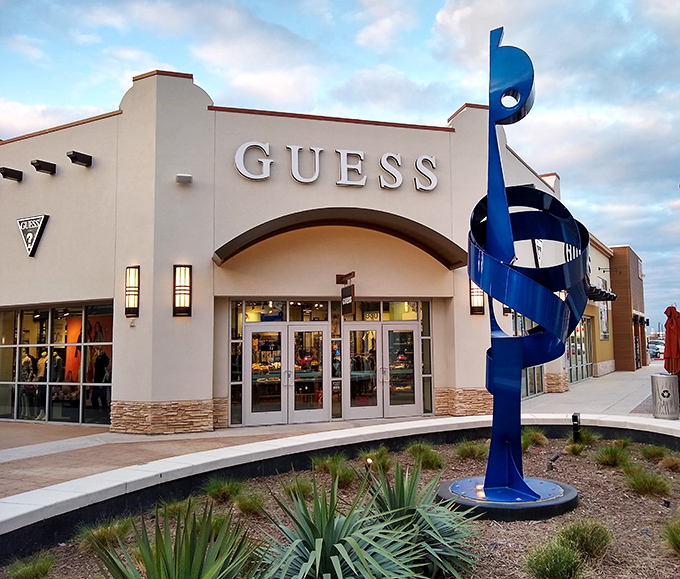 Modern stonework and attractive lighting transform outlet shopping into an elegant retail experience.