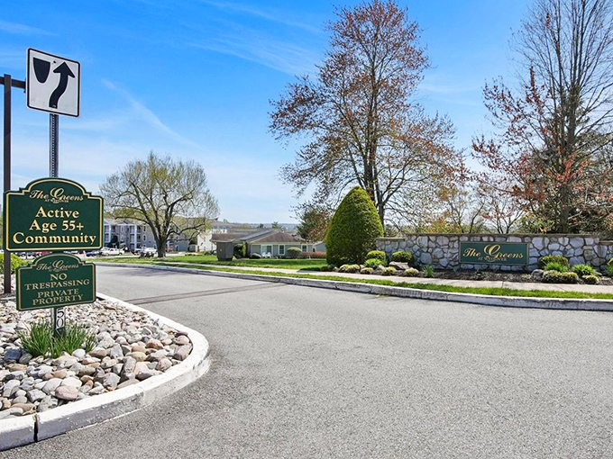 The Greens entrance sign stands proud, like it's announcing the best-kept secret in town.
