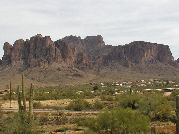 Superstition Mountains loom majestically, offering free hiking entertainment that rivals any expensive theme park experience you've ever enjoyed/