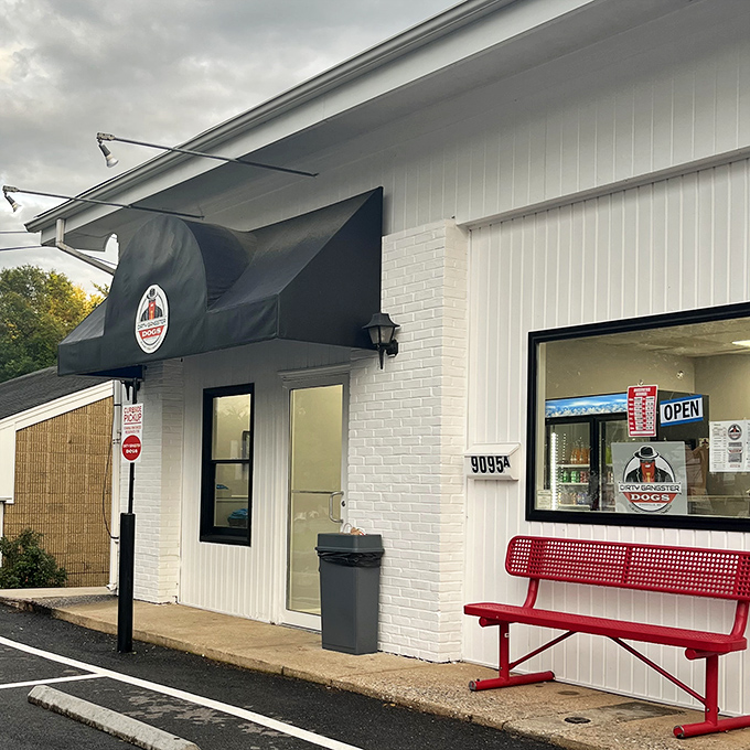 That red bench outside Dirty Gangster Dogs has witnessed countless "first bite" moments of pure hot dog bliss.