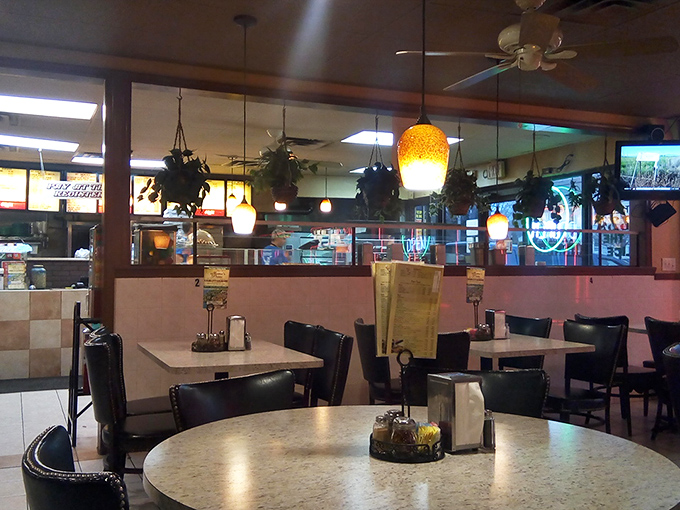 Hanging plants and colorful pendant lights create the cozy vibe that makes every bite taste like coming home.