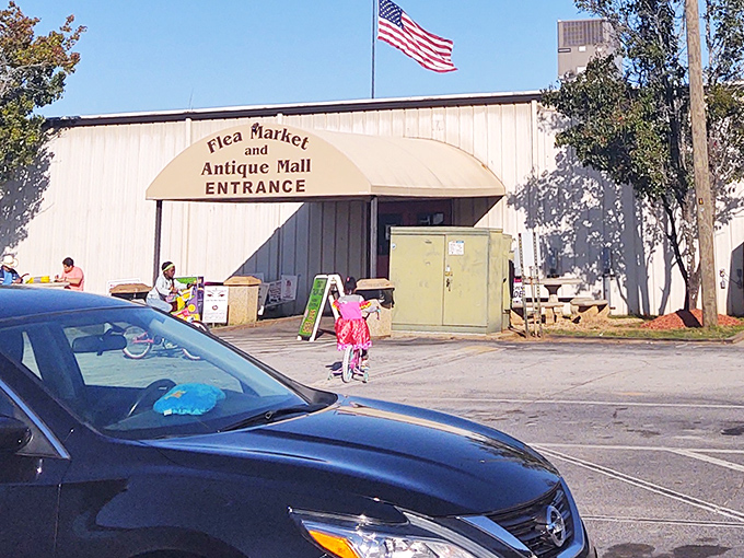 The American flags flutter welcome at Peachtree Peddlers, where patriotism meets the thrill of the hunt in climate-controlled comfort.