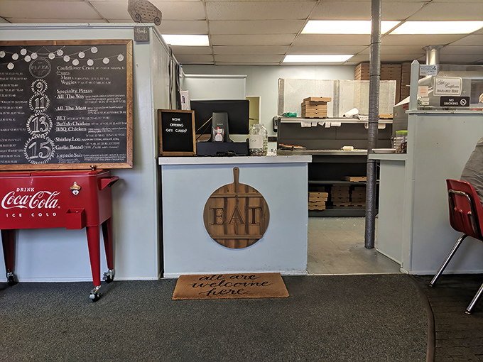 That vintage Coca-Cola cooler and chalkboard menu board scream authentic neighborhood pizzeria vibes perfectly.