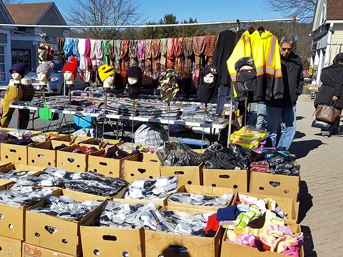 Organized chaos reigns as shoppers navigate between vendors displaying everything imaginable under blue skies.