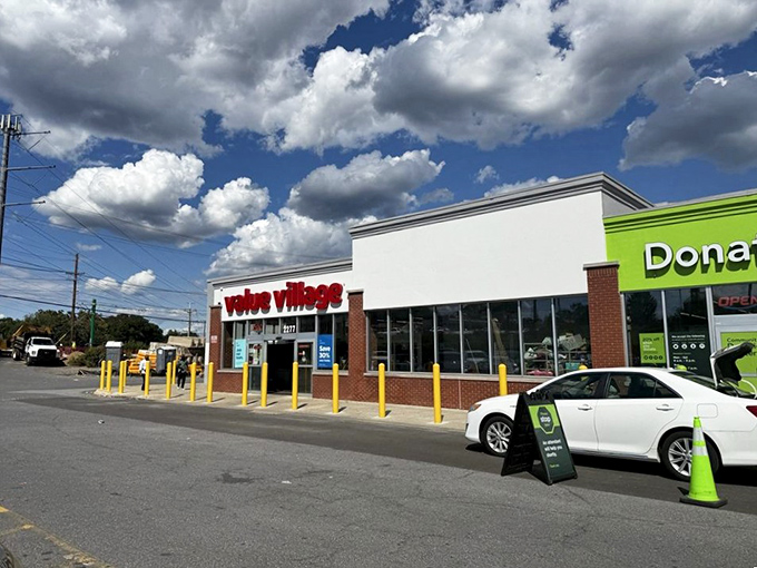 Bright yellow safety poles guard Value Village like sentries protecting a treasure vault. The Fort Knox of affordable fashion awaits your discovery!