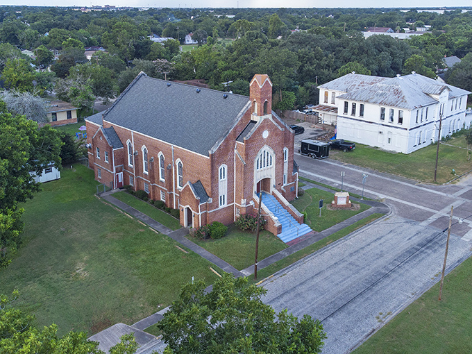 Red brick church and white buildings create a picture-perfect scene of small-town Texas charm.