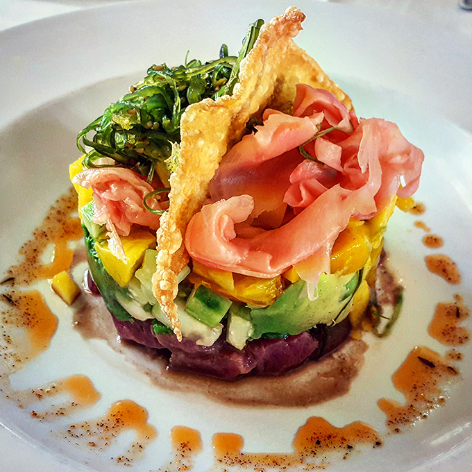 The Ahi Poke Tower stands tall and proud, a colorful architectural marvel that tastes even better than it looks – and it looks magnificent.