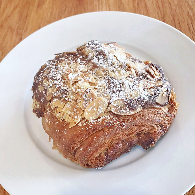 This almond croissant wears powdered sugar and sliced almonds like a French pastry chef's crown of glory.